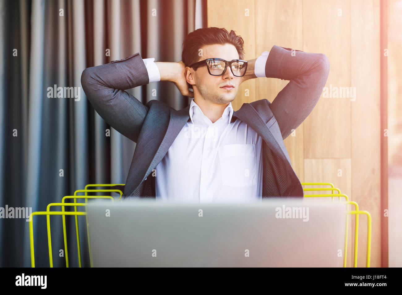 A time for relax. Young, happy businessman is relaxing in his office ...