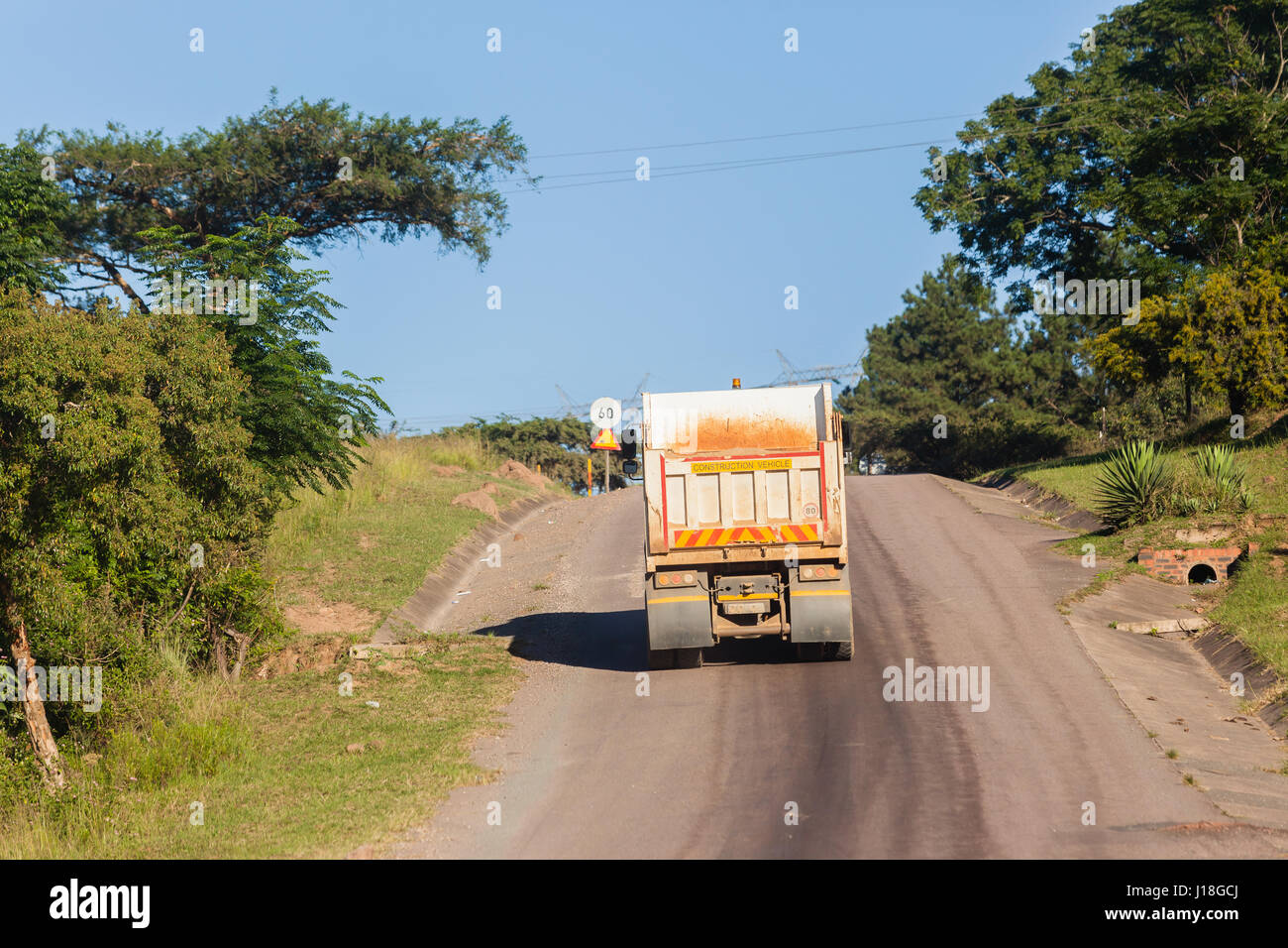 Industrial truck vehicle closeup travels countryside road towards ...