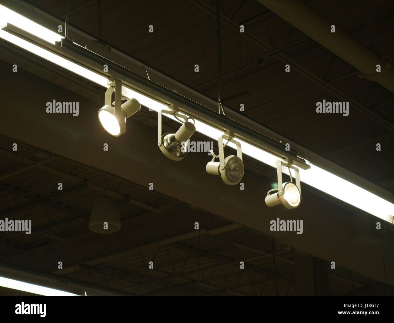 Set of spot lights on a rail hanging from the ceiling Stock Photo - Alamy