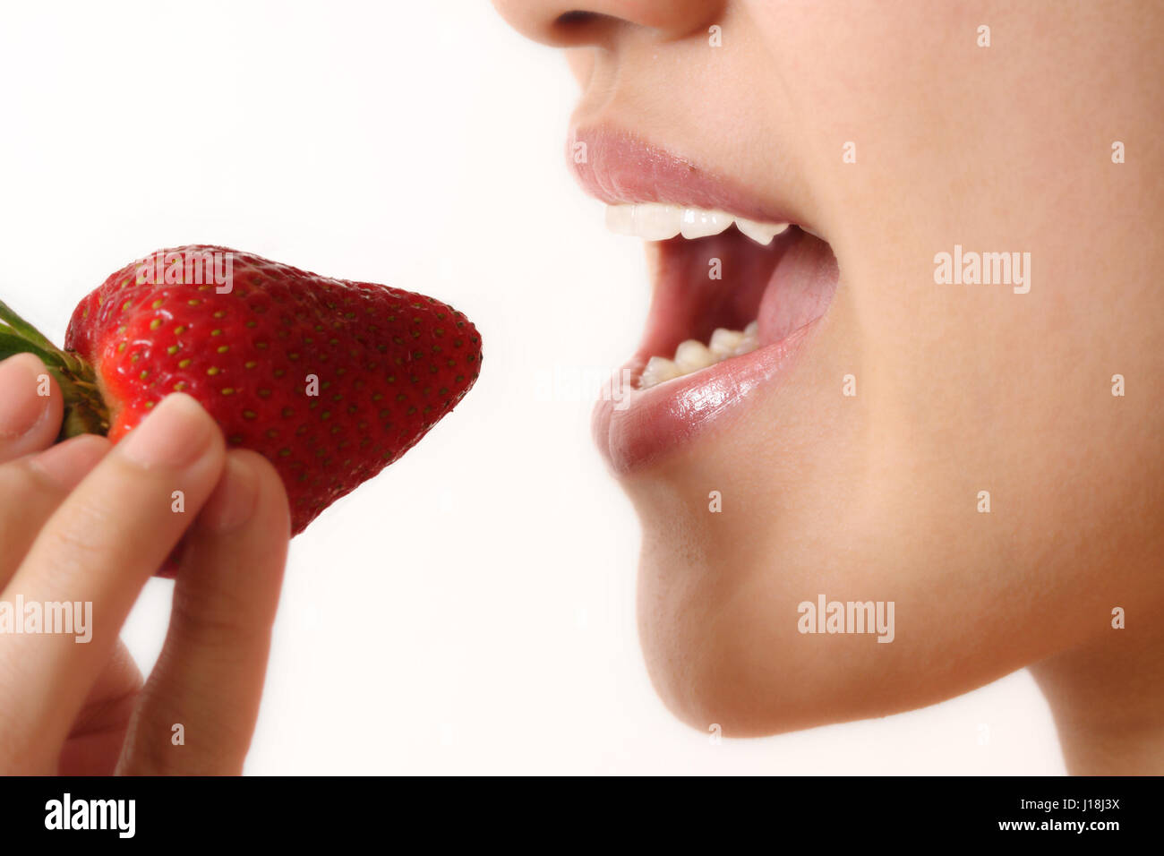 A woman eating a strawberry Stock Photo - Alamy