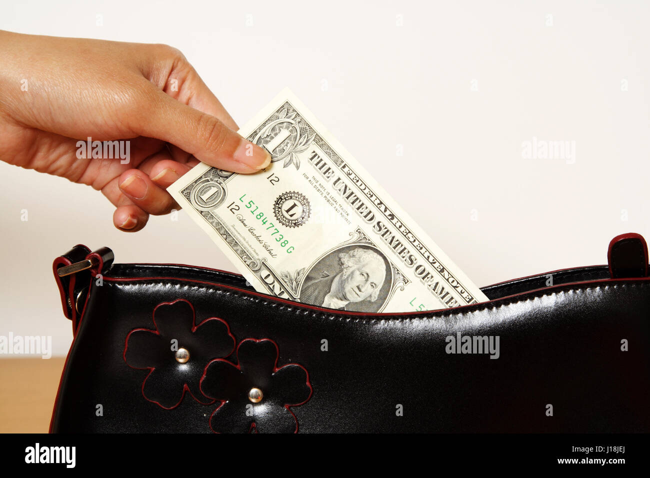 A woman taking out one dollar bill from a purse Stock Photo - Alamy