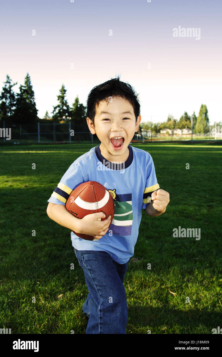 A happy boy playing football outdoor Stock Photo - Alamy