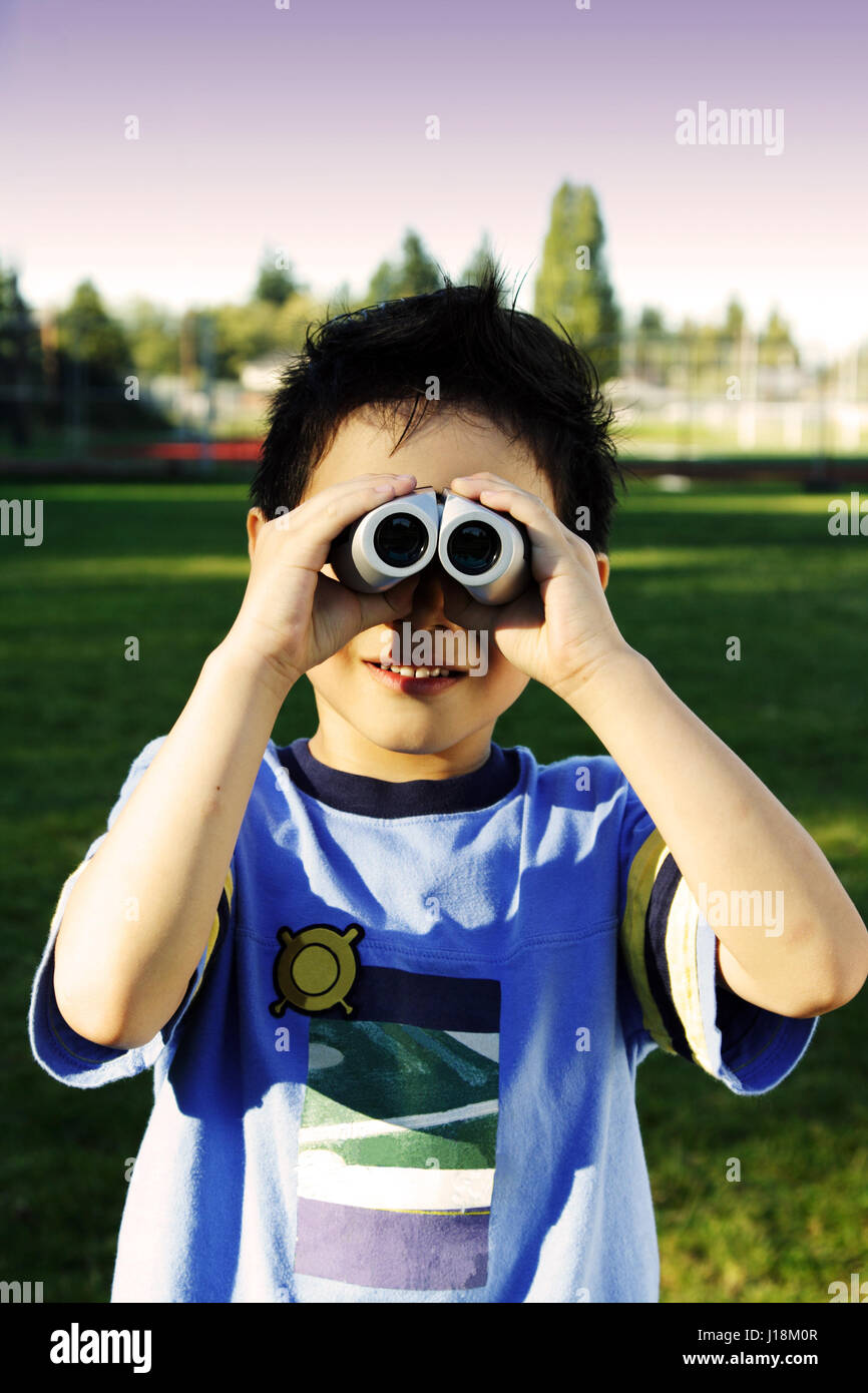 A boy looking through a binocular Stock Photo - Alamy