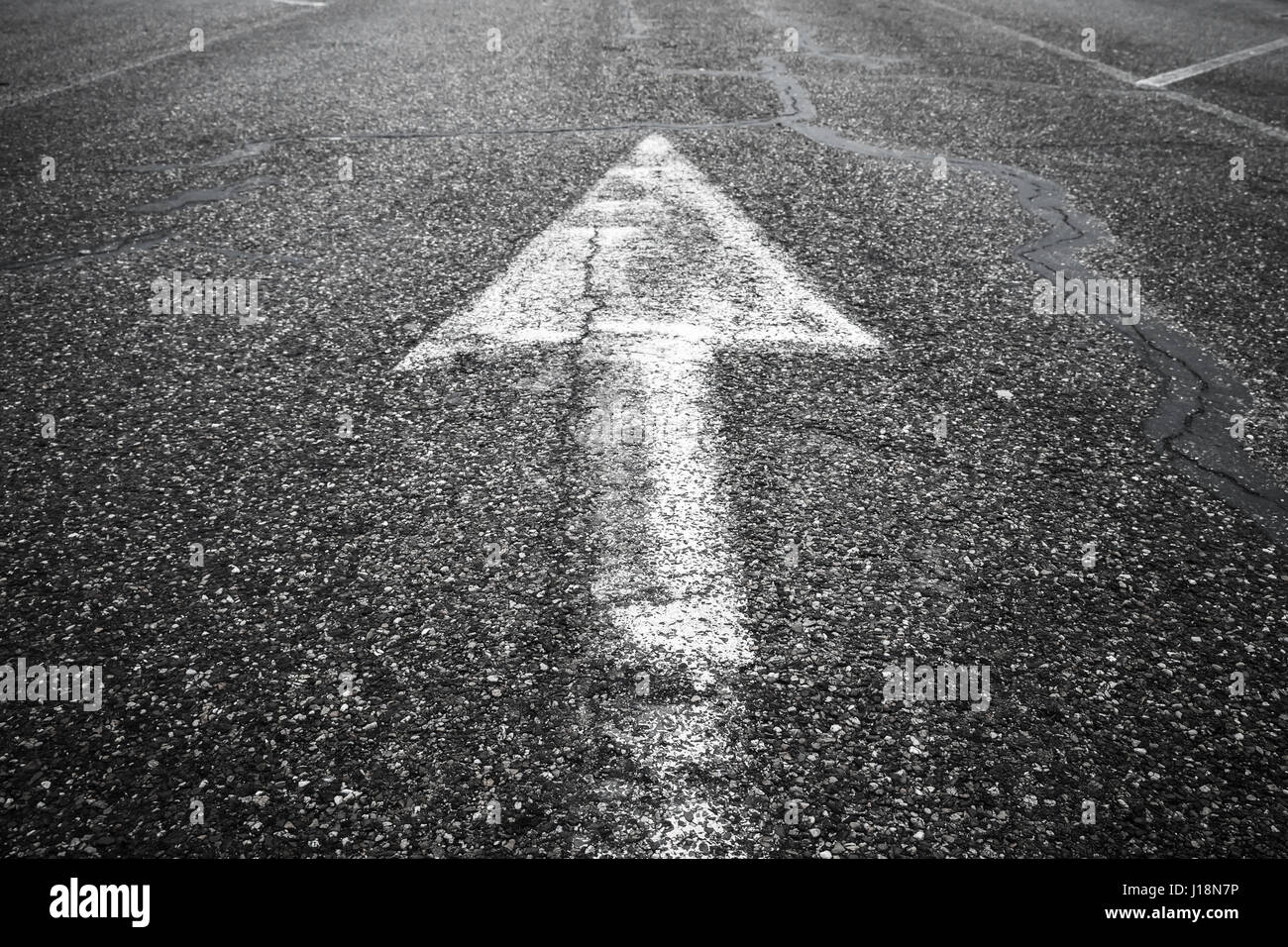 White arrow goes up over highway asphalt, straight drive direction ...