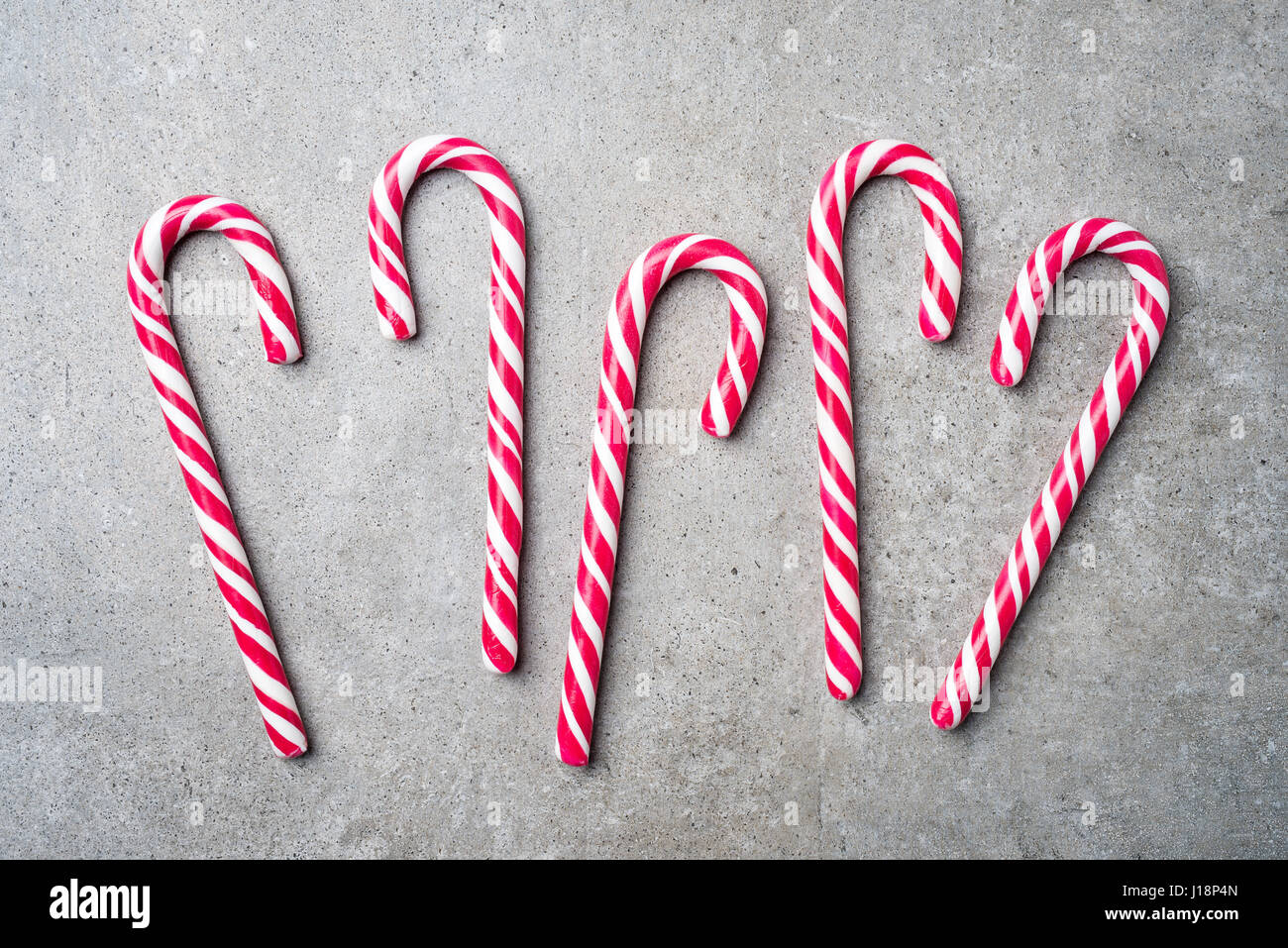 Candy canes on gray stone background Stock Photo - Alamy