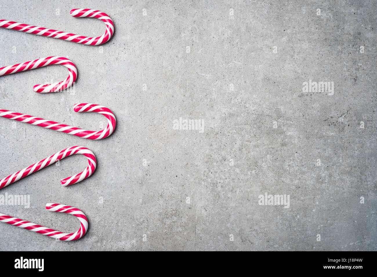Candy canes on gray stone background Stock Photo - Alamy
