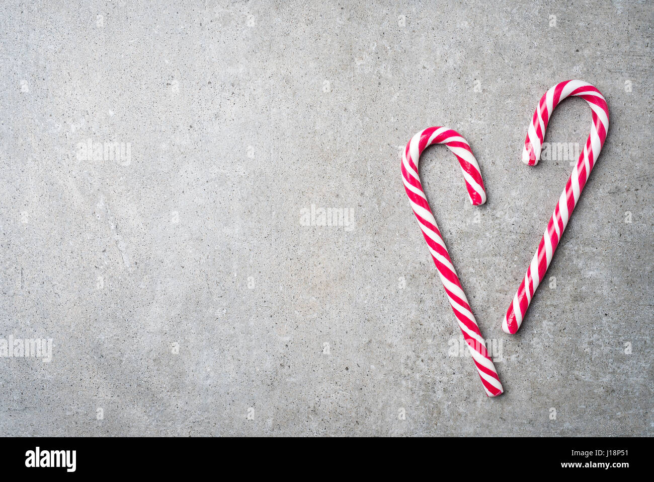 Candy canes on gray stone background Stock Photo - Alamy