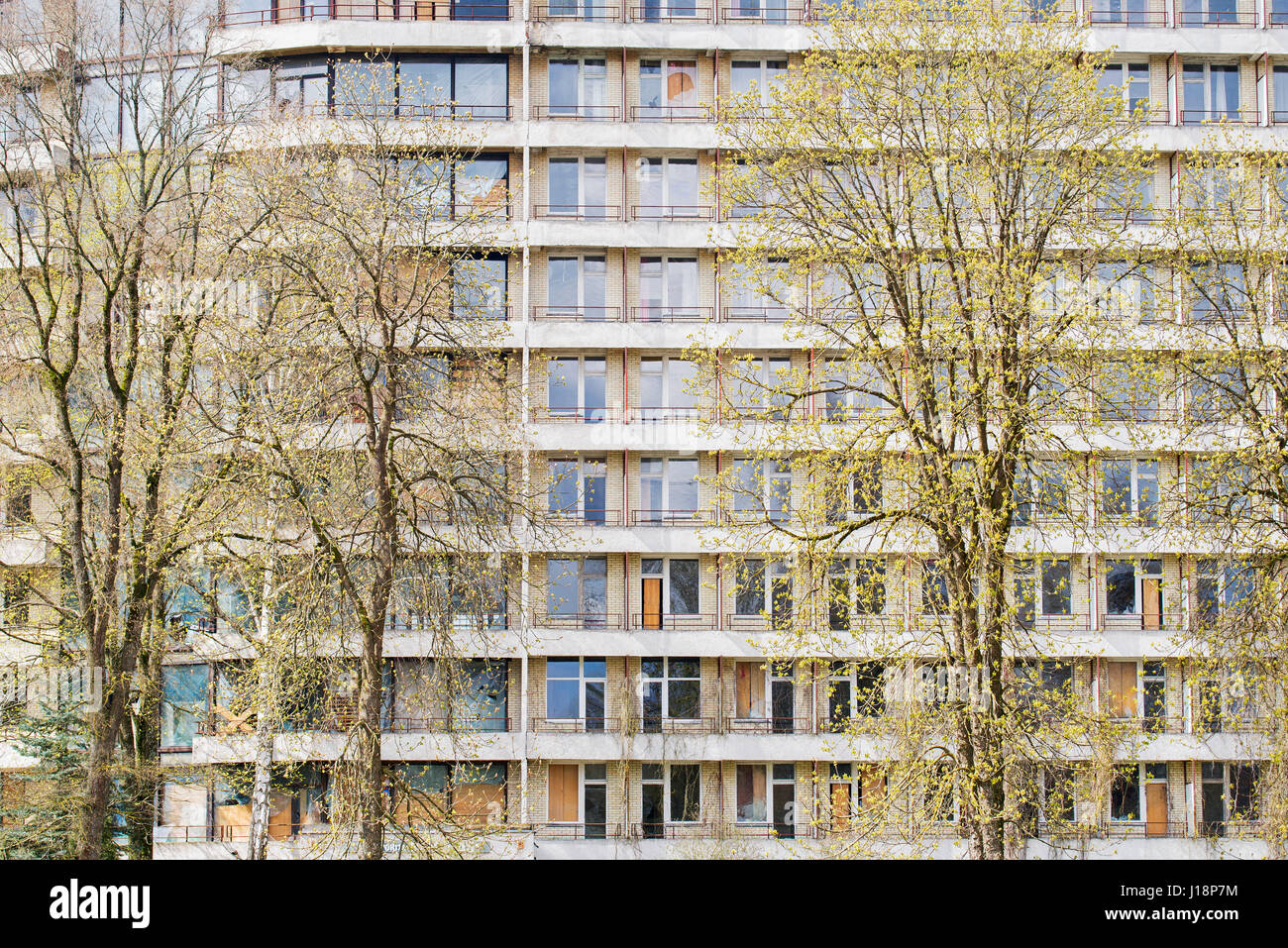 Abandoned old hotel with lot of windows and balconies surrounded by ...