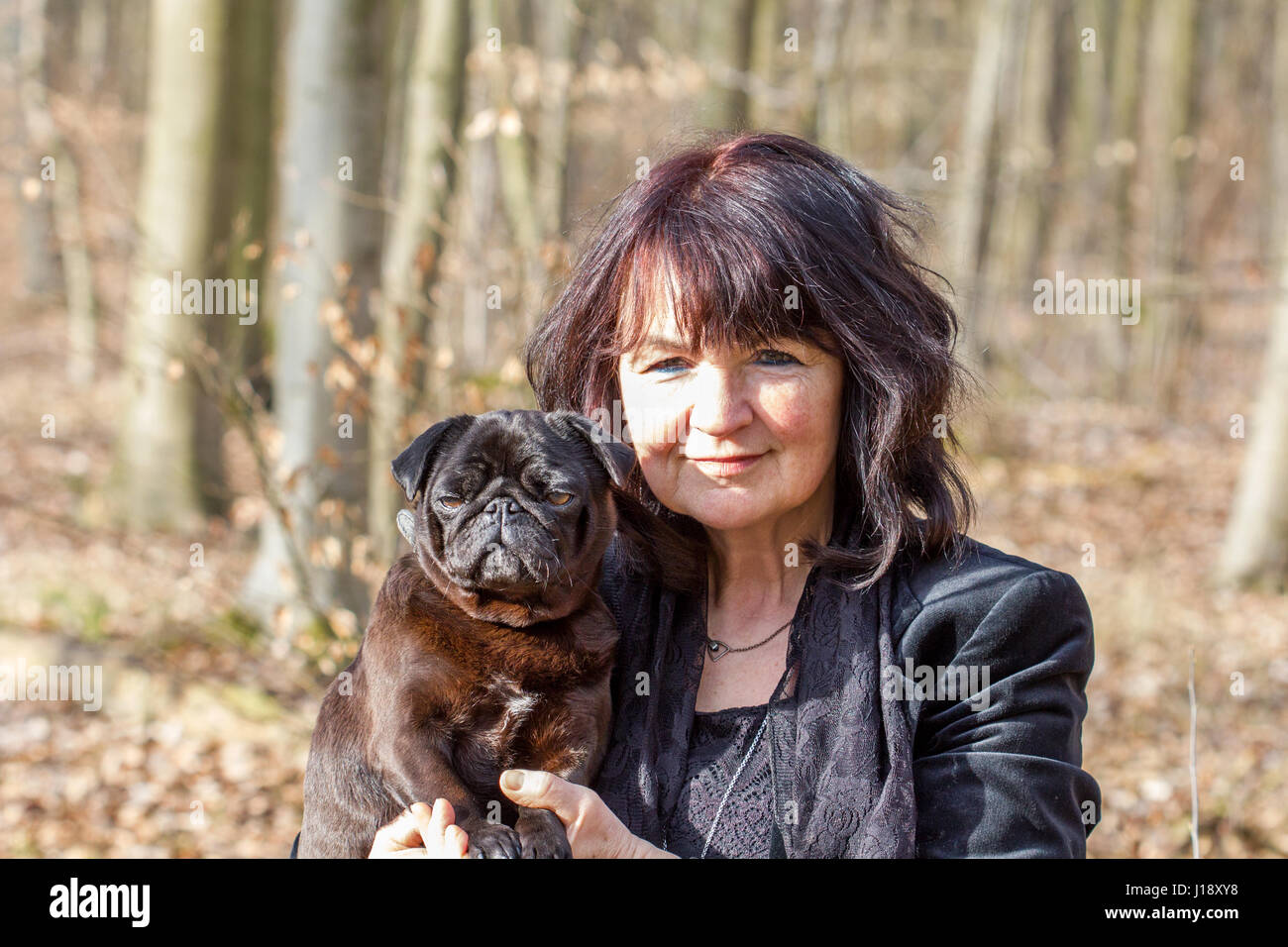 A woman and a black pug in the forest Stock Photo - Alamy