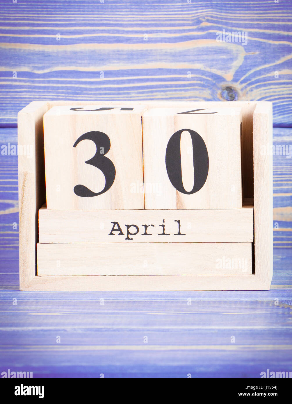 April 30th. Date of 30 April on wooden cube calendar, purple board as ...