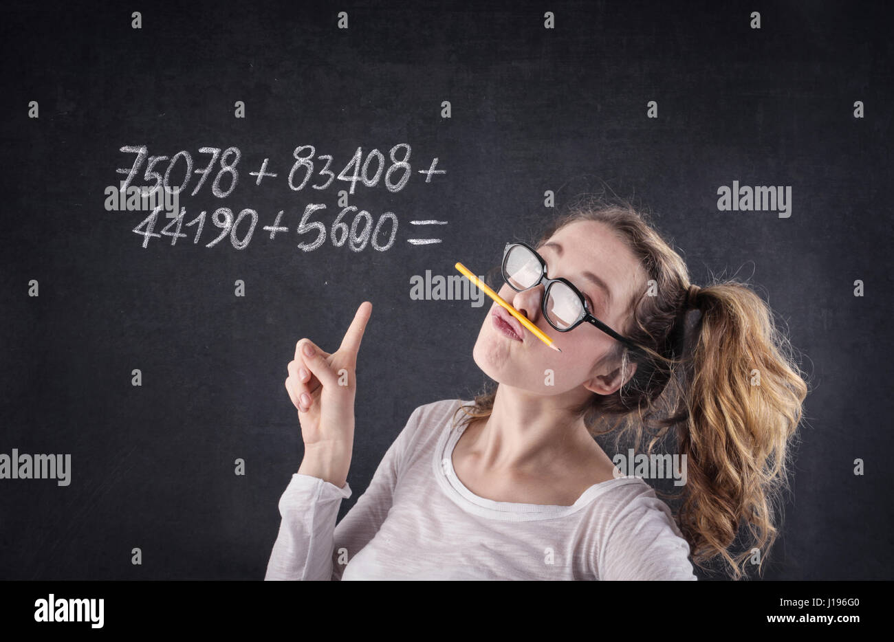 Blond girl with pencil doing math Stock Photo - Alamy