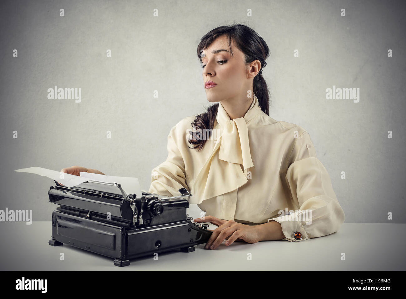 Serious woman working with typewriter Stock Photo - Alamy