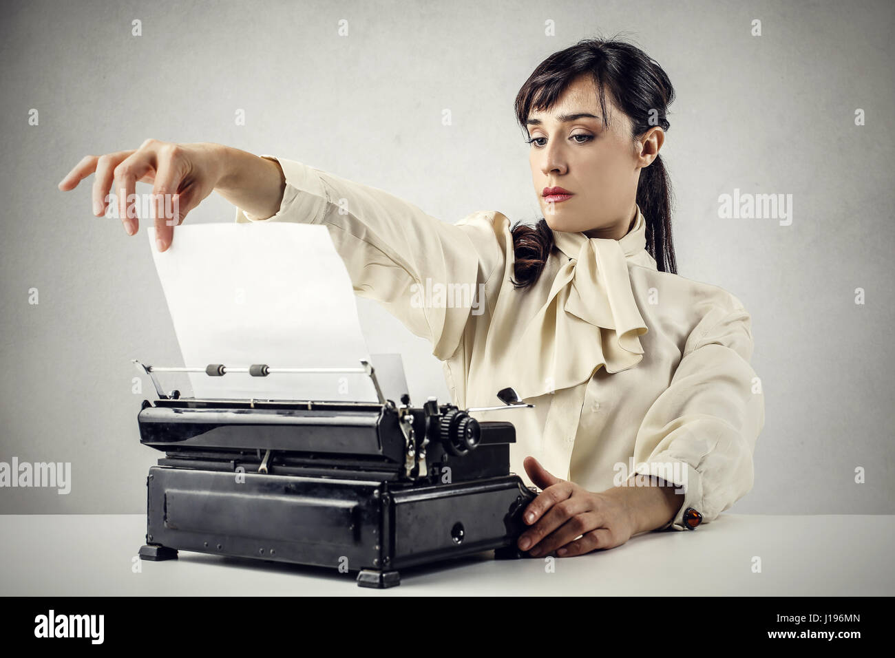 Serious woman with typewriter Stock Photo - Alamy