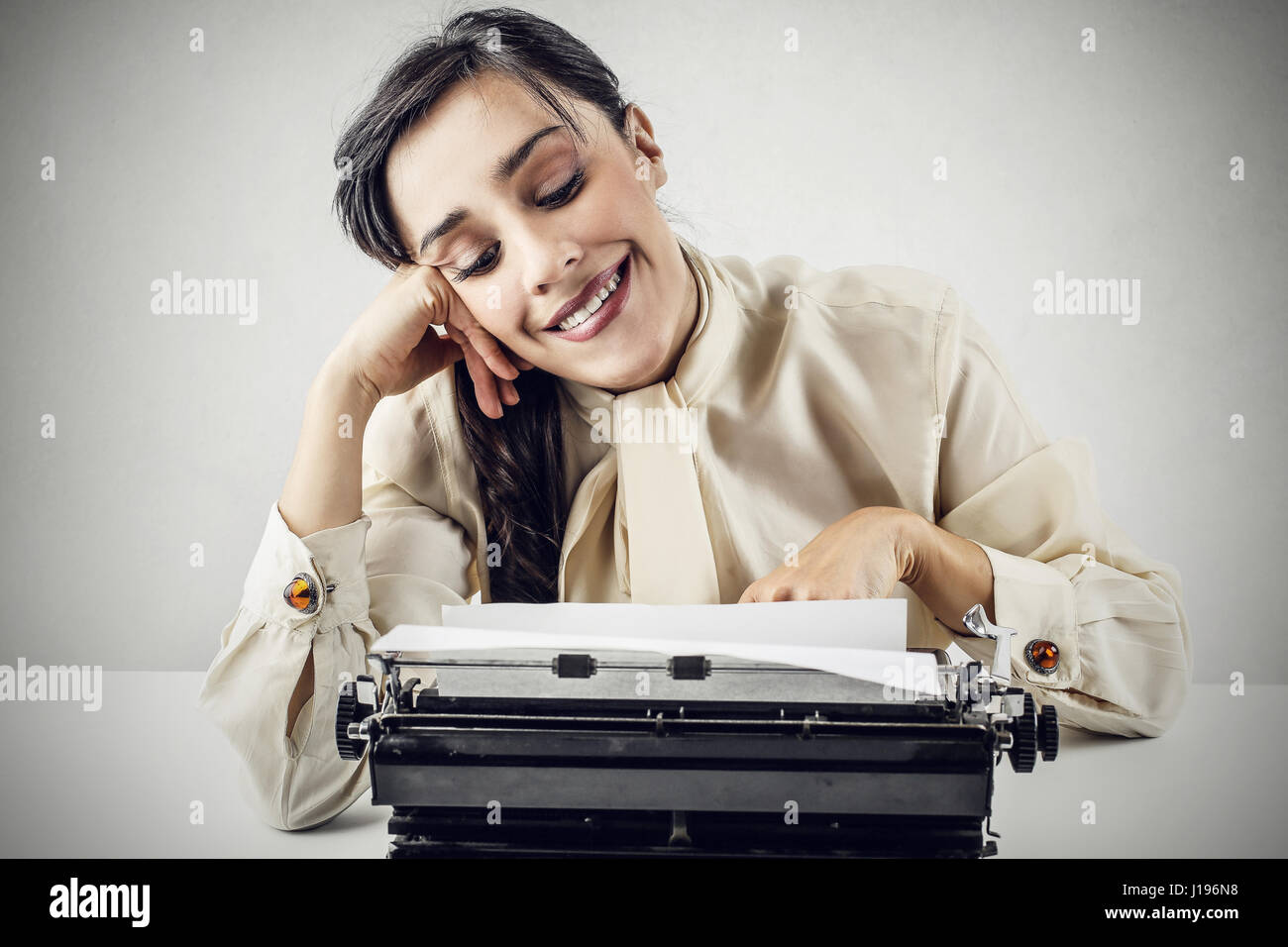 Brunette woman writing with typewriter Stock Photo - Alamy