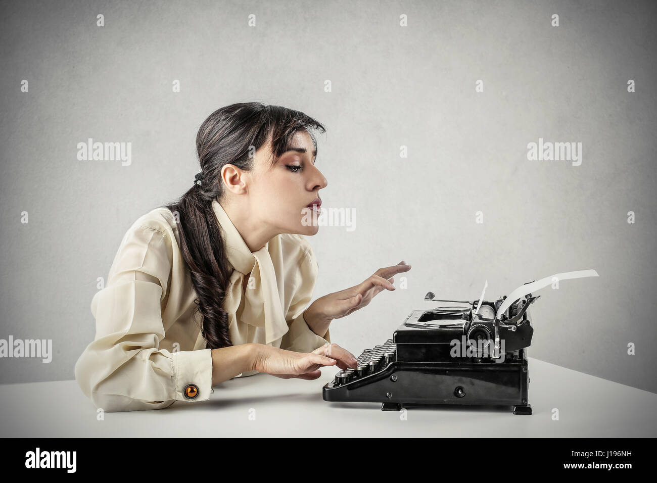 Brunette woman working with typewriter Stock Photo - Alamy