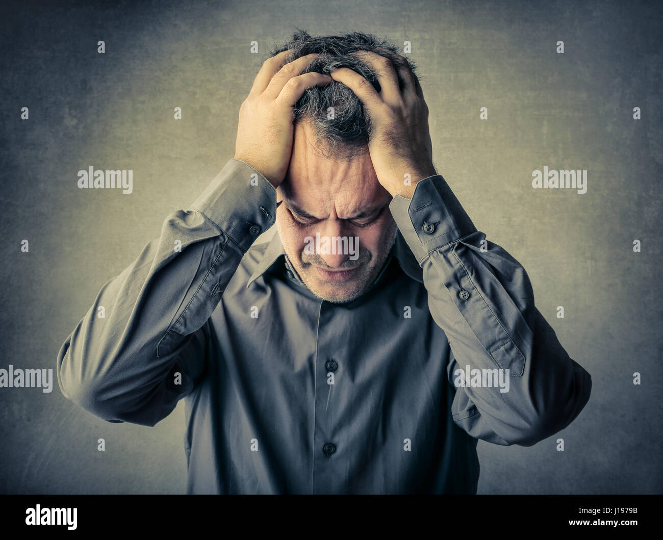 Stressed man holding his head Stock Photo - Alamy