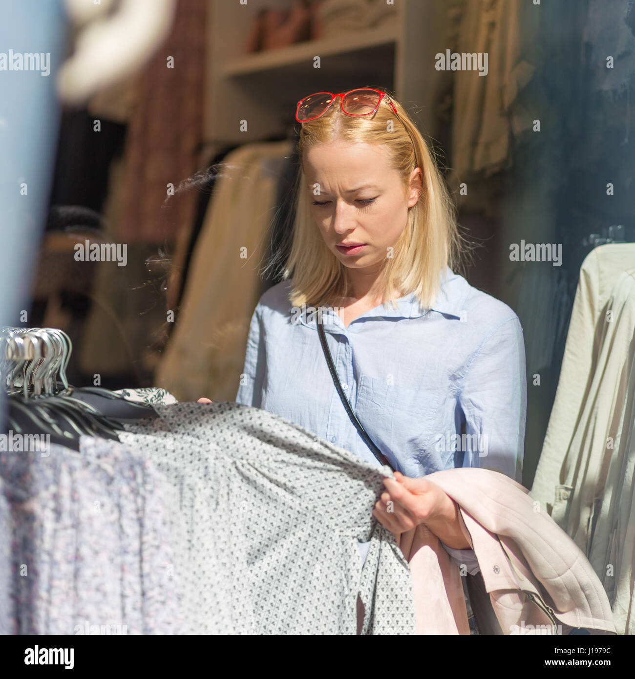 Beautiful woman shopping fashionable clothes in clothing store Stock ...