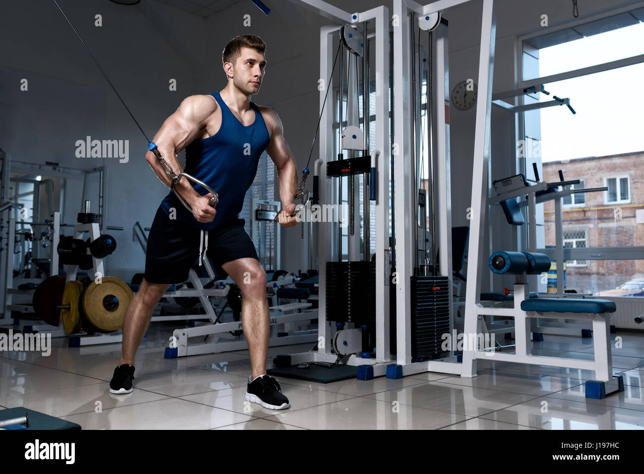 Man is exercising on a training machine in the gym Stock Photo - Alamy