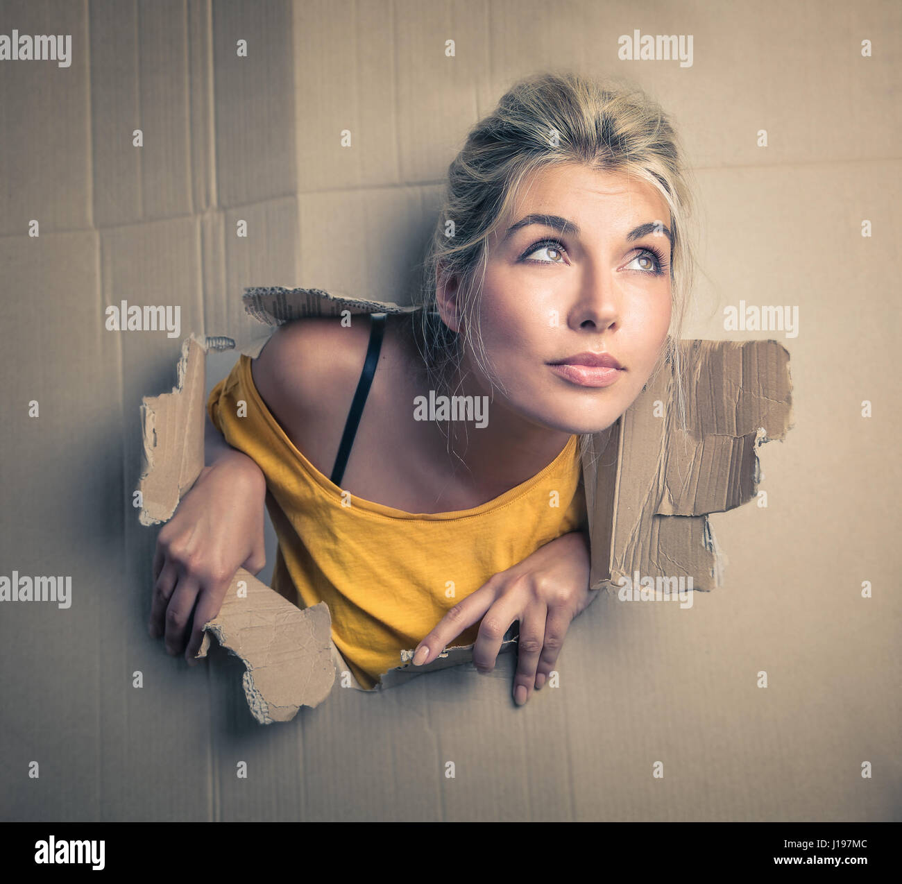 Woman breaking through paper box Stock Photo - Alamy