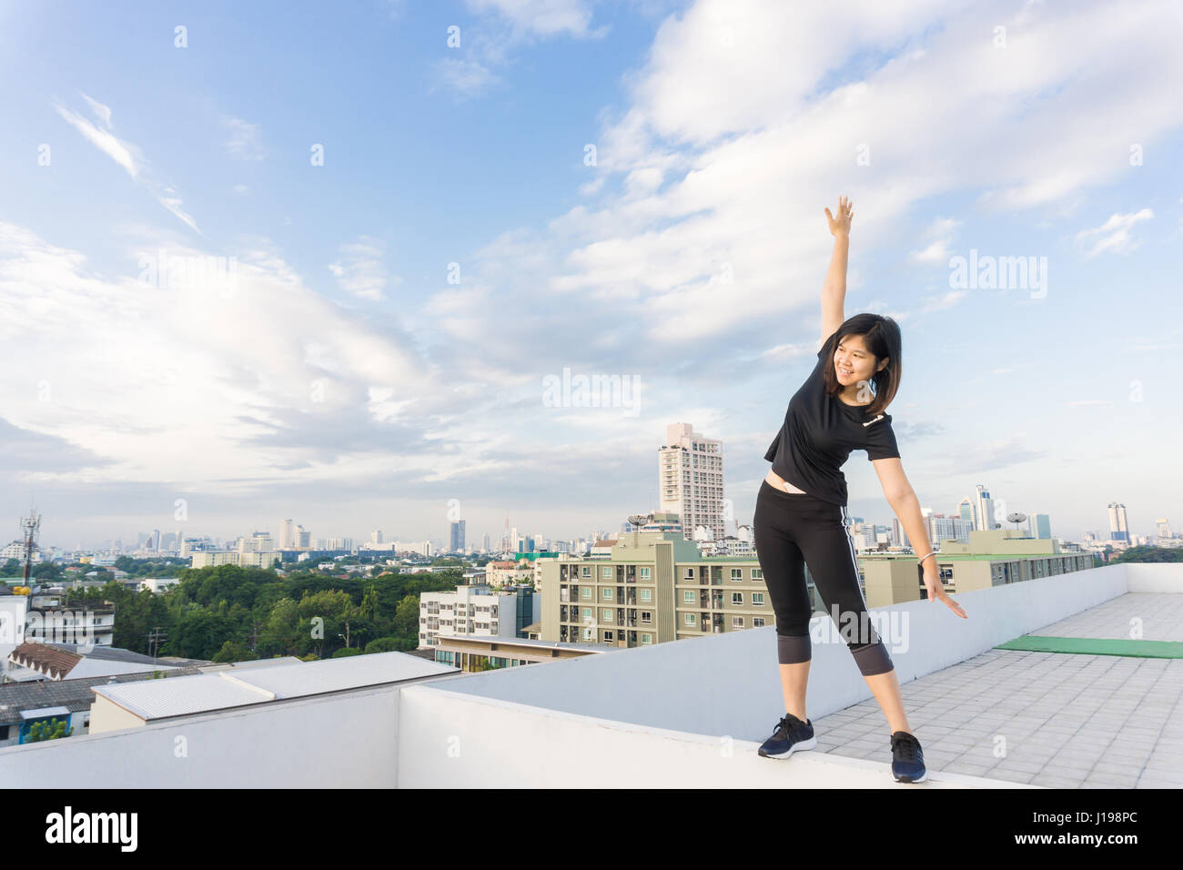 Fitness runner body closeup doing warm-up routine on roof top building ...