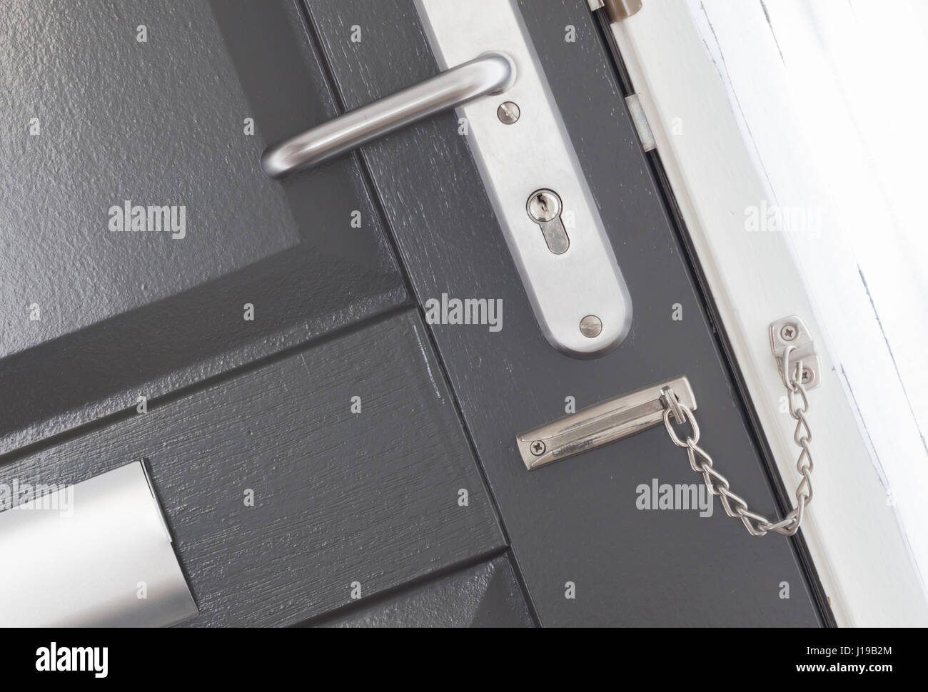 Door chain on a grey door, security measures Stock Photo - Alamy