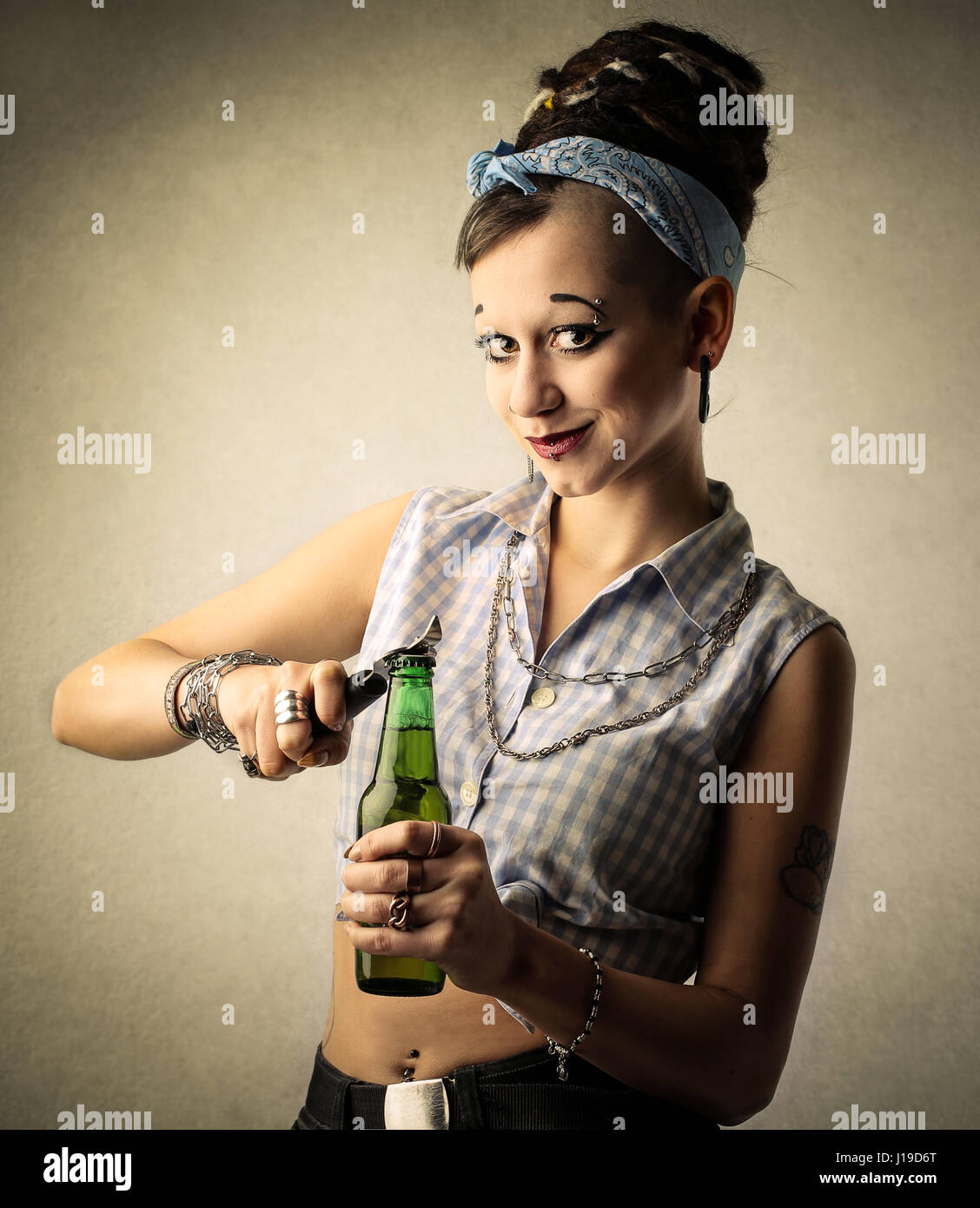 Alternative woman opening beer Stock Photo - Alamy