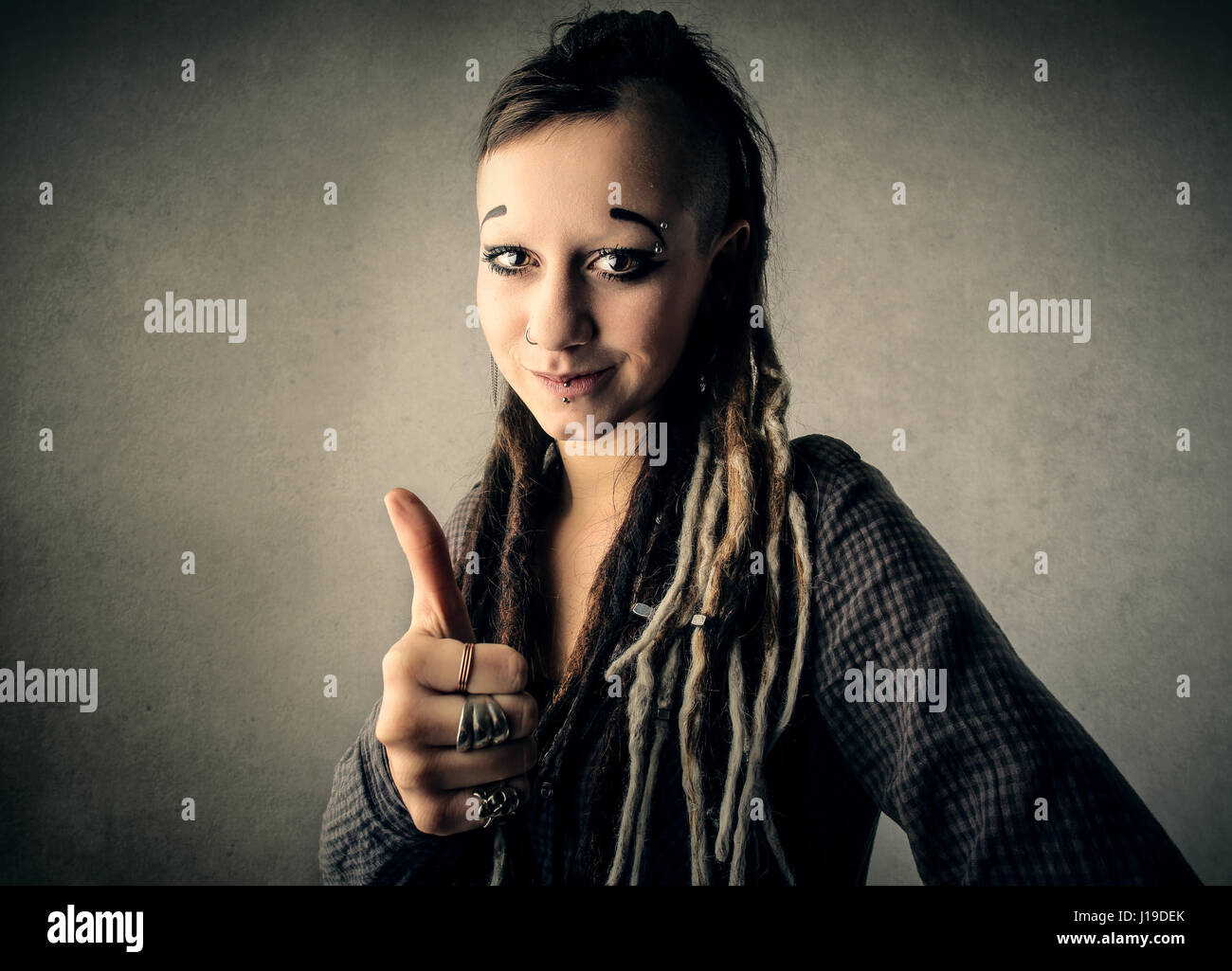 Alternative woman showing like sign Stock Photo - Alamy