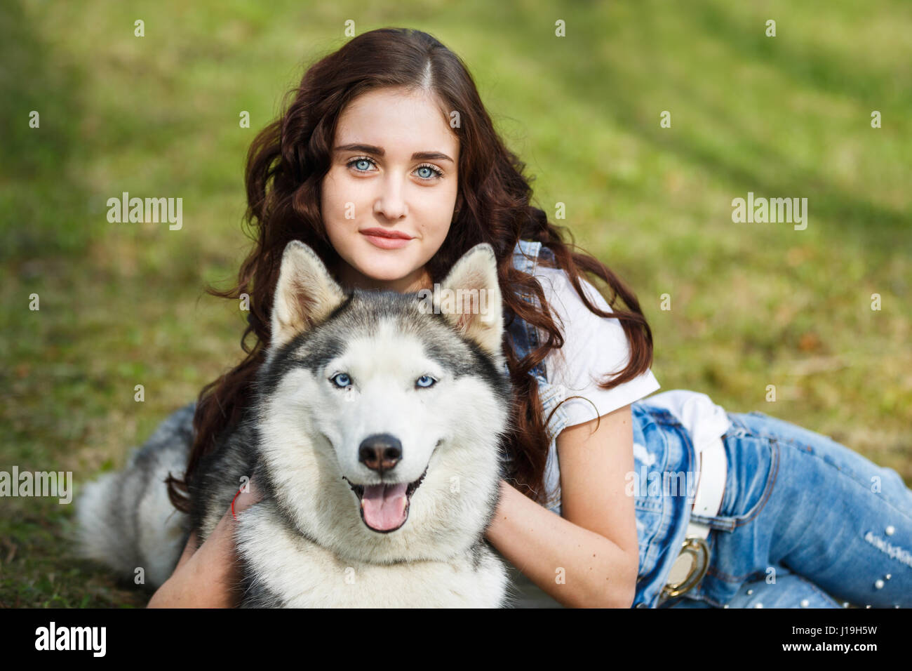 Teenage girl is hugging the husky dog outdoors Stock Photo - Alamy