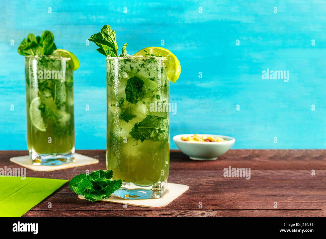 A photo of mojito cocktails with mint leaves, wedges of lime, and a ...