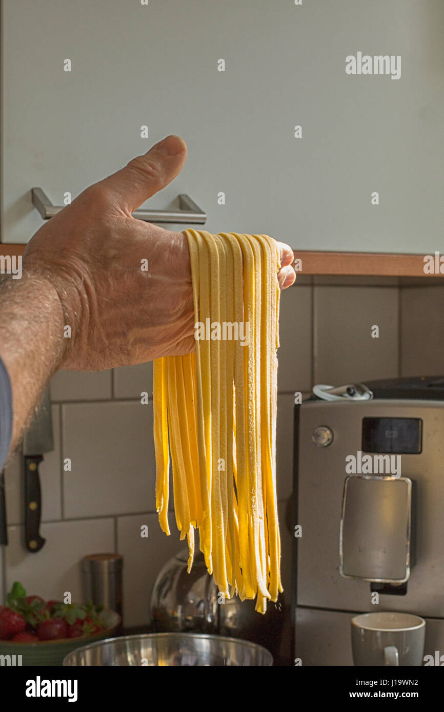 Hand holding home made pasta Stock Photo - Alamy