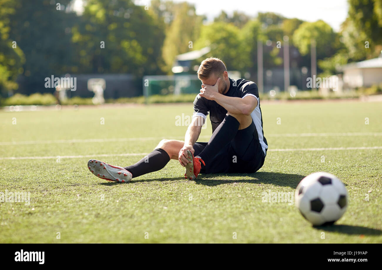 injured soccer player with ball on football field Stock Photo - Alamy