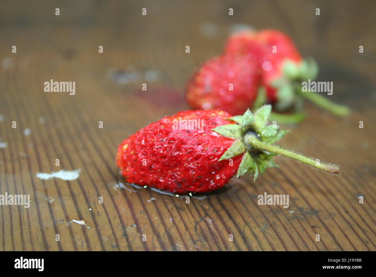Strawberry left on the table in the rain Stock Photo - Alamy