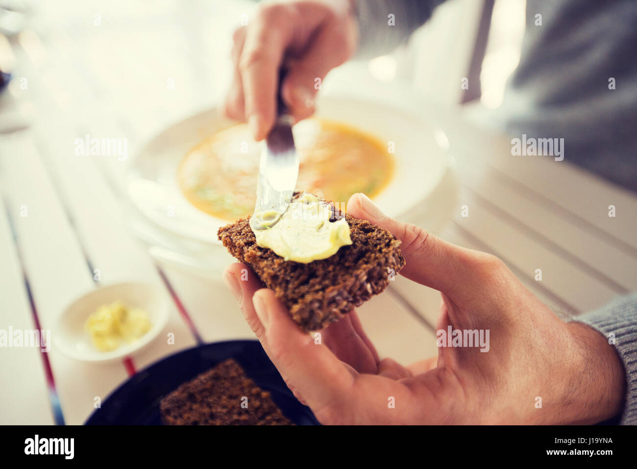 close up of hands applying butter to bread Stock Photo - Alamy