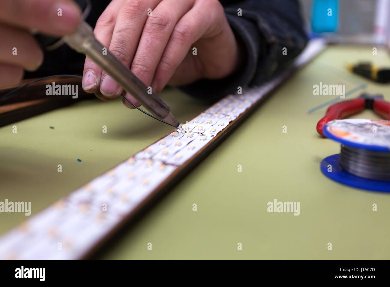 Worker creating a straight line of led bands Stock Photo - Alamy