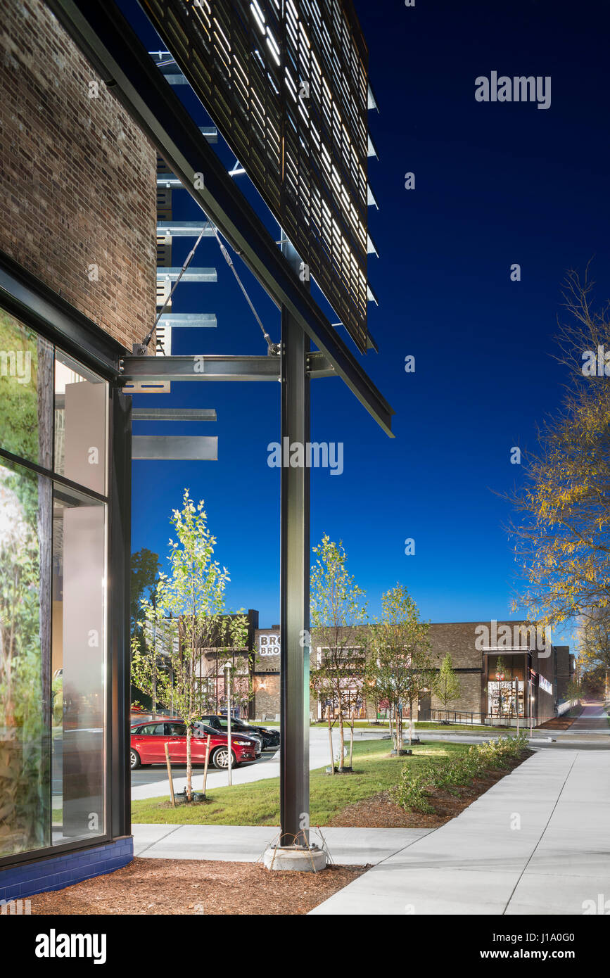 Detail of backlit corrugated steel scrim above store at dusk. Arbor ...