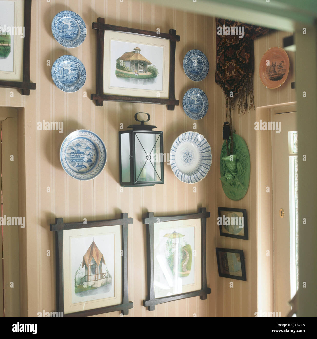 Art and antique tableware hanging on striped wall Stock Photo - Alamy