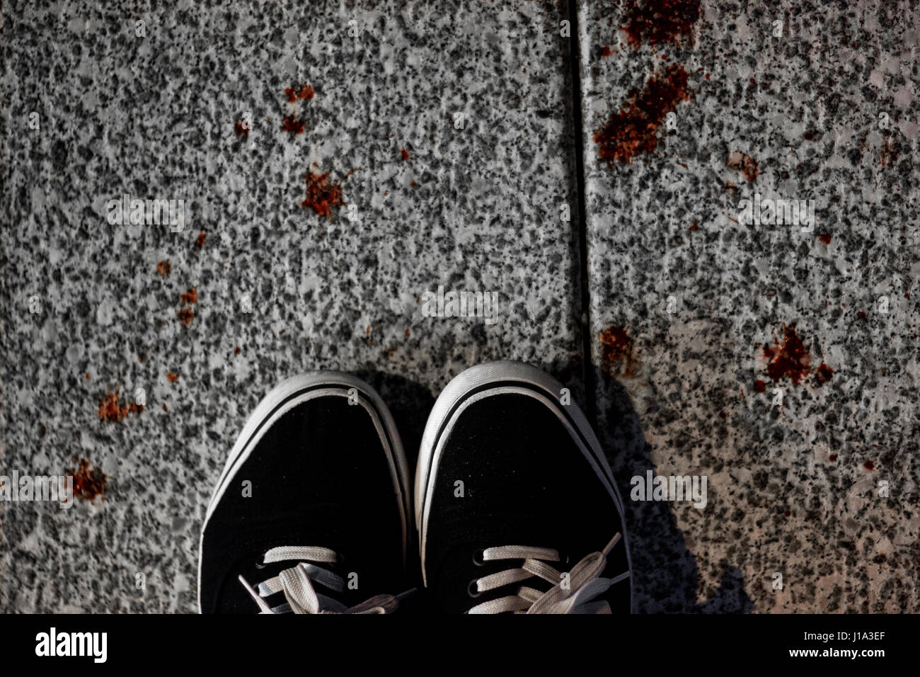 A photograph of shoes with blood patters on the pavement Stock Photo ...
