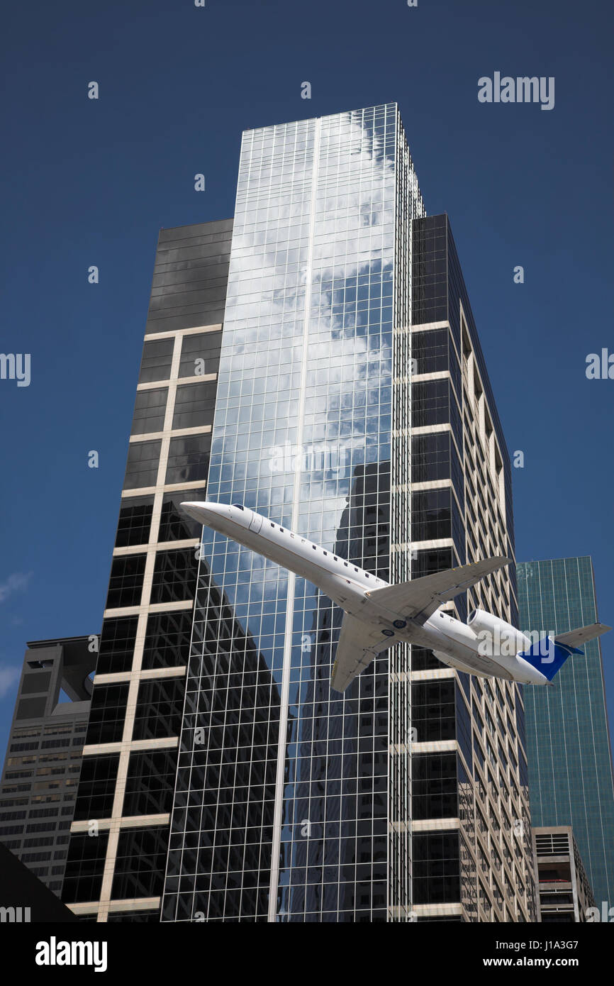 Jet airplane taking off near large modern buildings downtown, blue sky ...