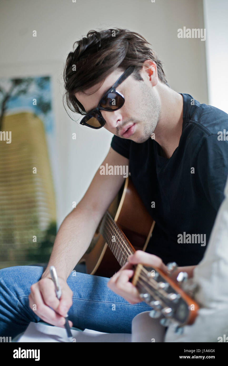 Young musician writing songs on an acoustic guitar Stock Photo - Alamy