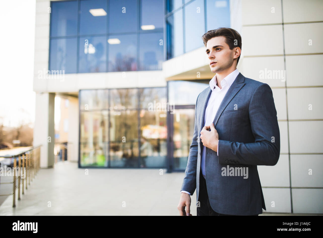 Business man outdoors in front of office building Stock Photo - Alamy