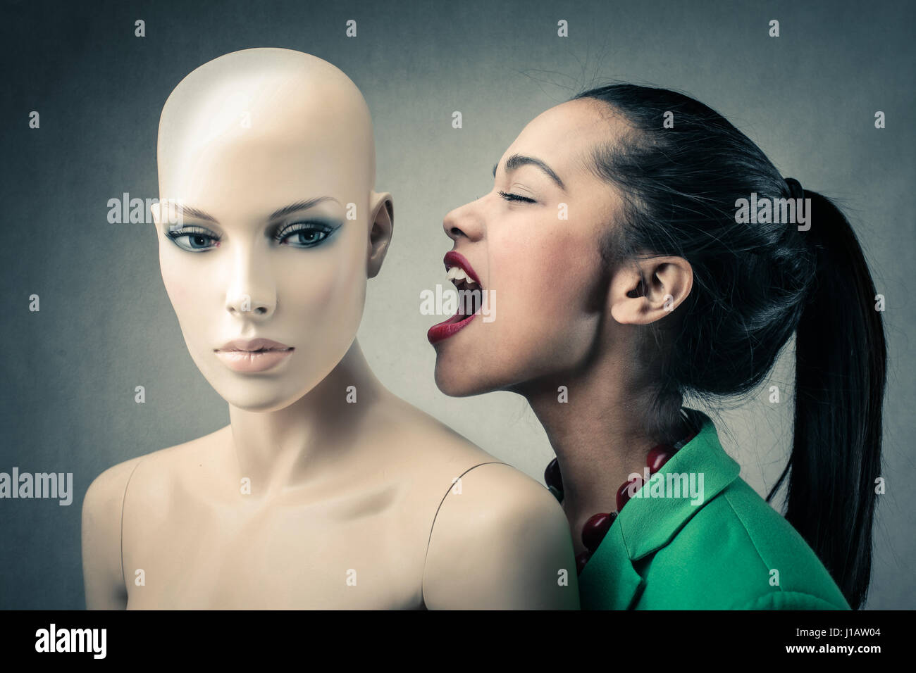 Young woman talking to mannequin Stock Photo - Alamy