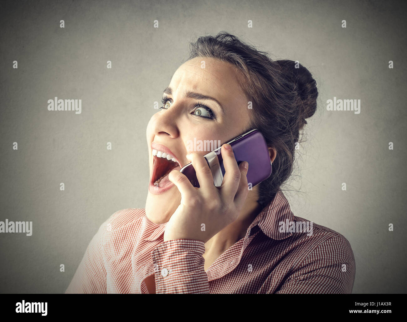 Brunette woman telephoning and yelling Stock Photo - Alamy