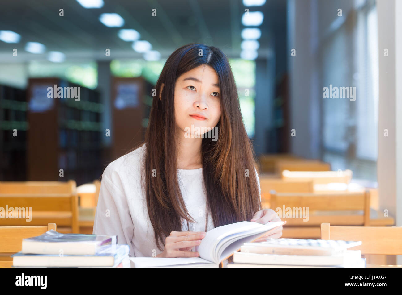 Happy student women sittng on wood chair light from window for reading ...