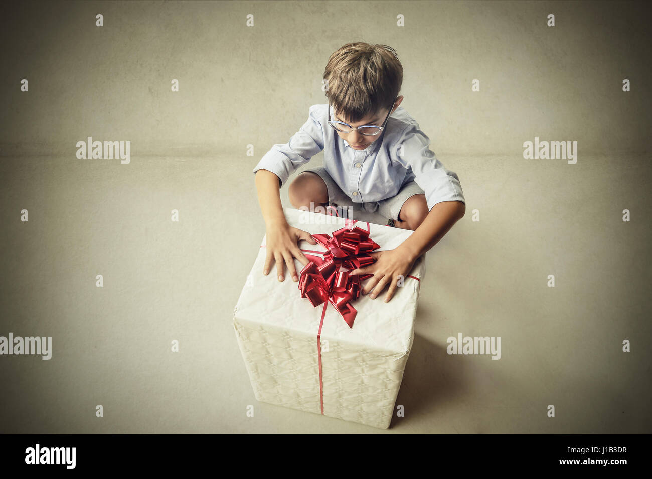 Young boy opening gift box Stock Photo - Alamy