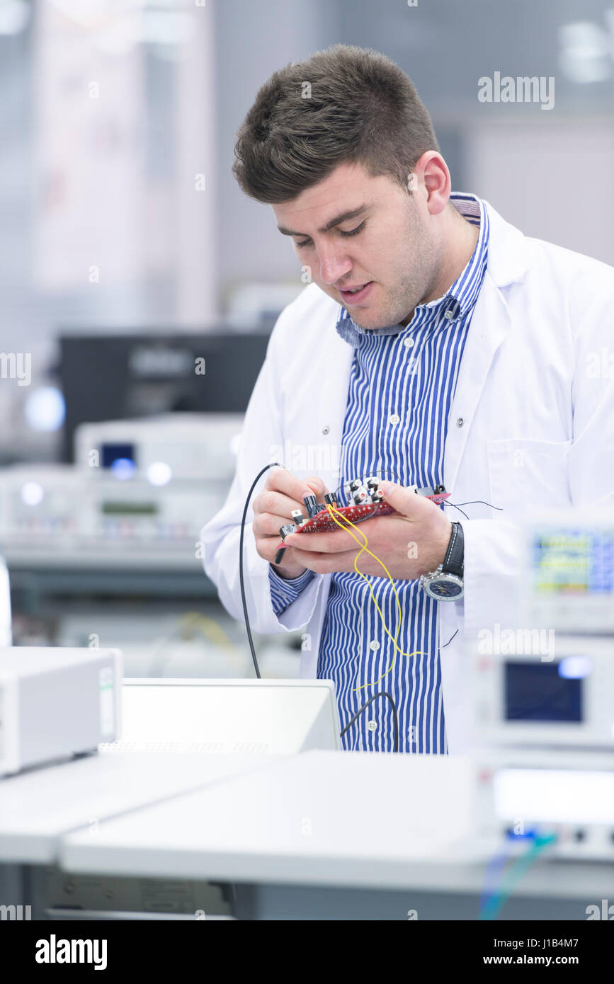 A science laboratory with a scientist investigating electrical ...