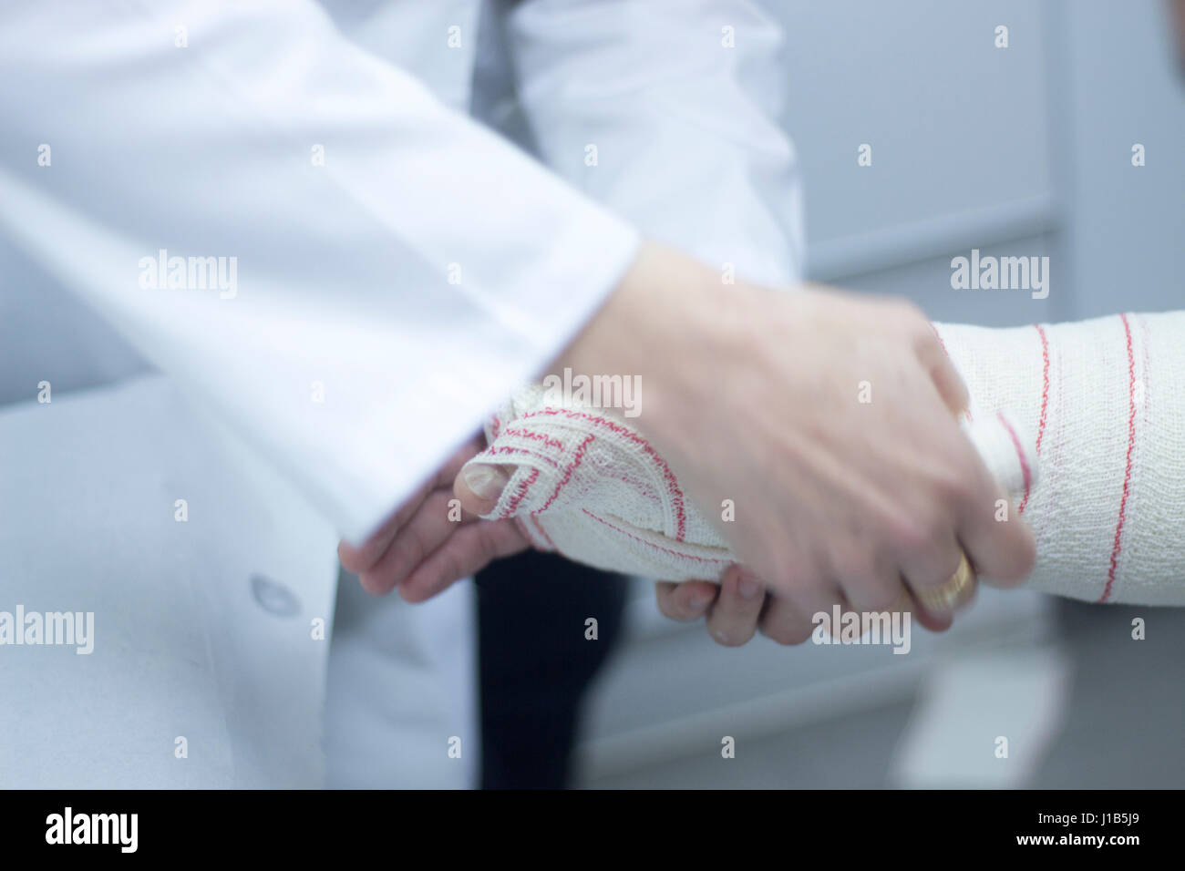 Doctor applying a plaster cast and bandages to patient forearm and ...