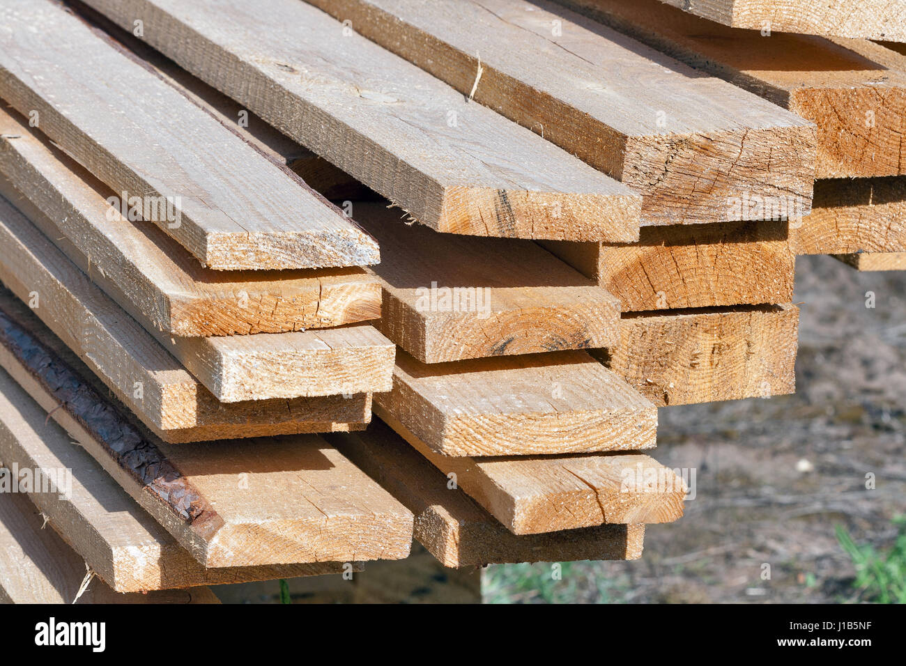 Ends of the rough pine boards in the outdoor stack for construction ...