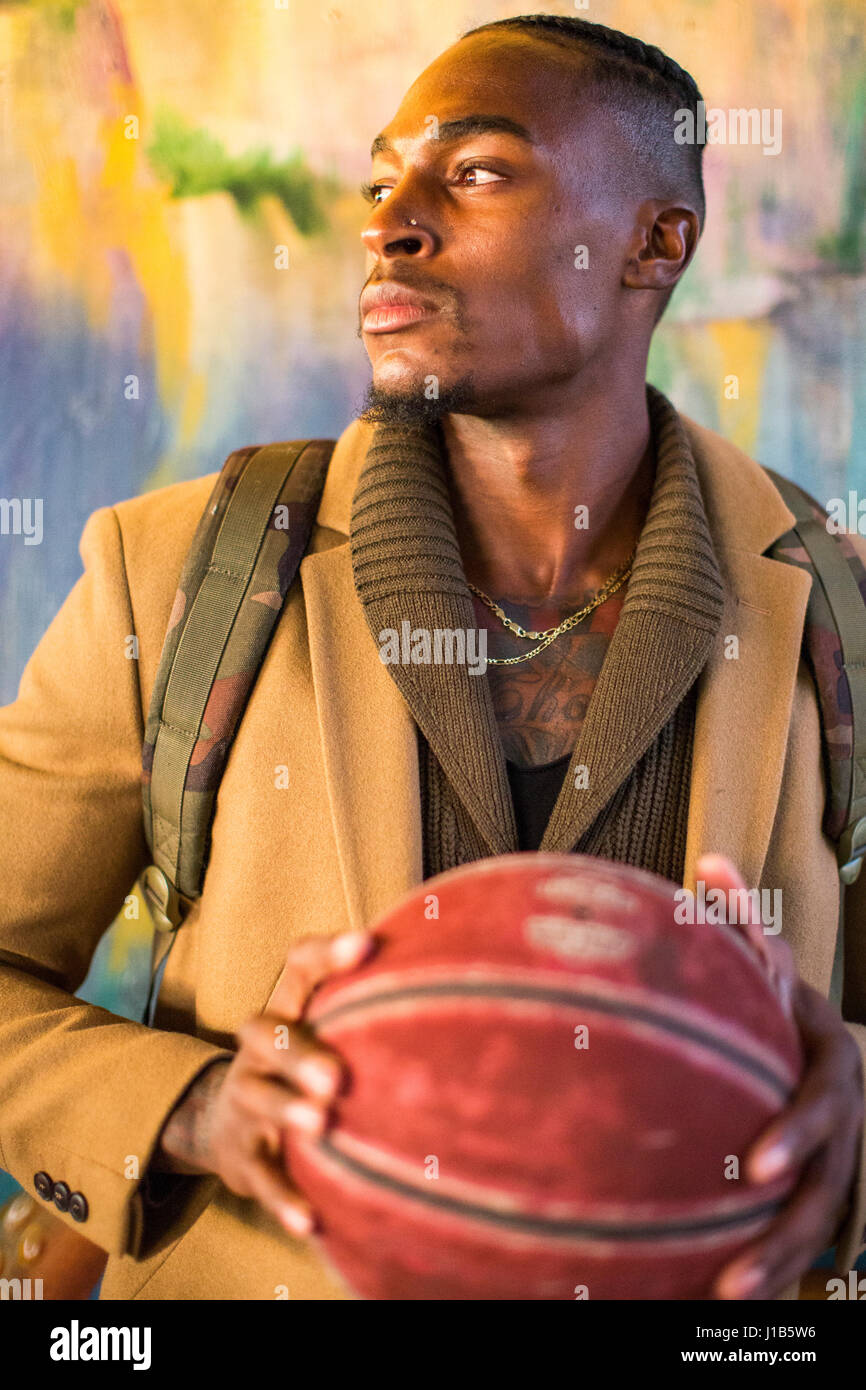 Black man wearing backpack holding basketball Stock Photo - Alamy