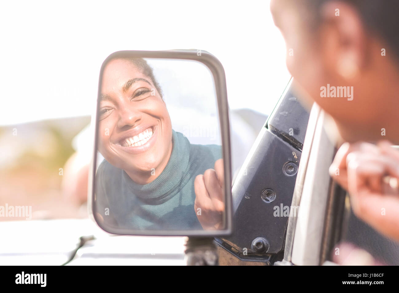 Reflection of African American woman in car mirror Stock Photo - Alamy