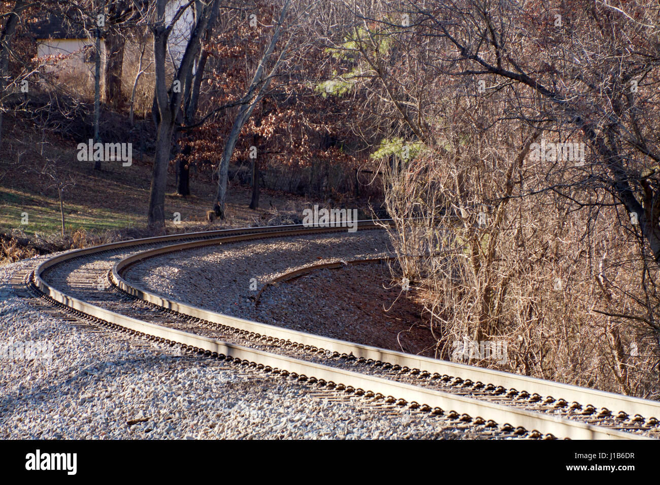 Train tracks make a strong curve around a bend leading into unknown ...